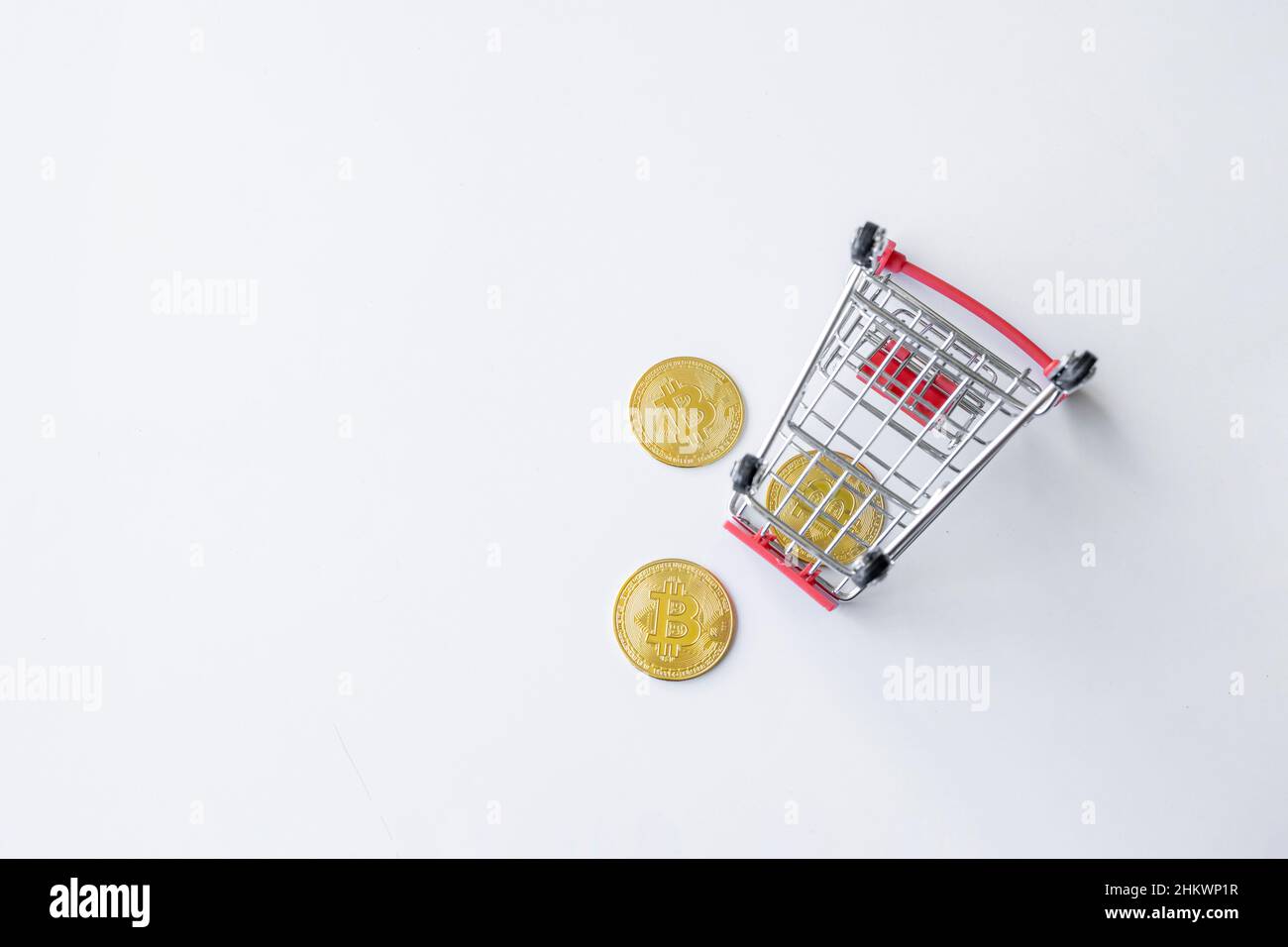 market down concept. golden bitcoin in shopping cart on white table ...