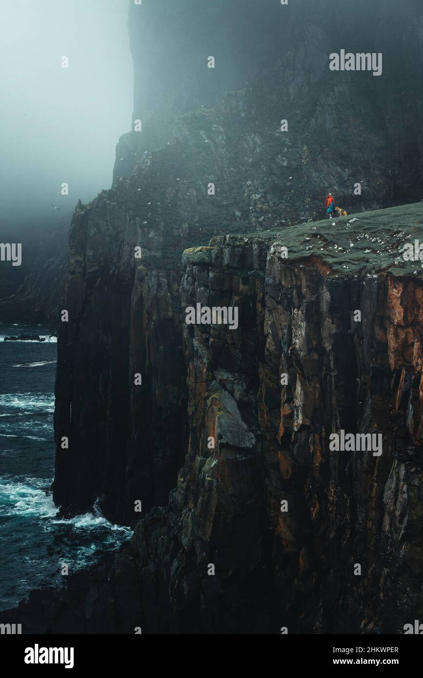 Vertical shot of the beautiful massive cliffs on a foggy day. Scotland ...