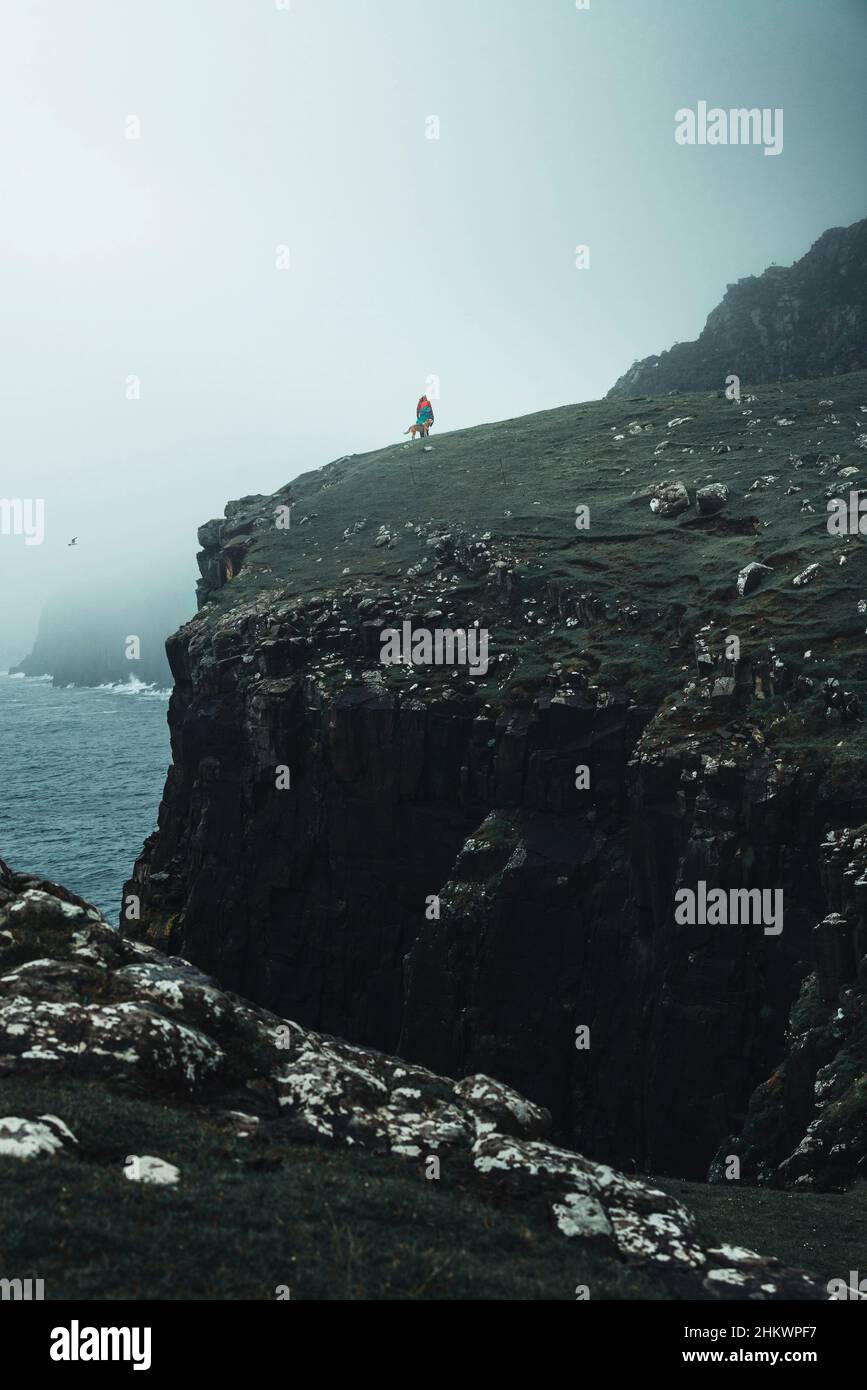 Vertical shot of the beautiful massive cliffs on a foggy day. Scotland ...