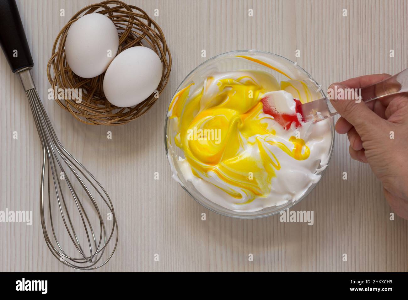 Making yellow colored whipped egg whites in theglass bowl. top view ...