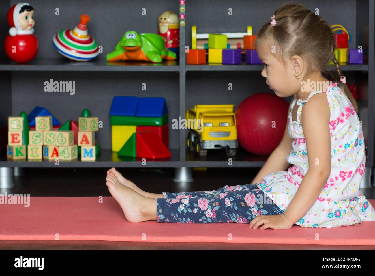 Child sitting on the matt before making exercises Stock Photo - Alamy