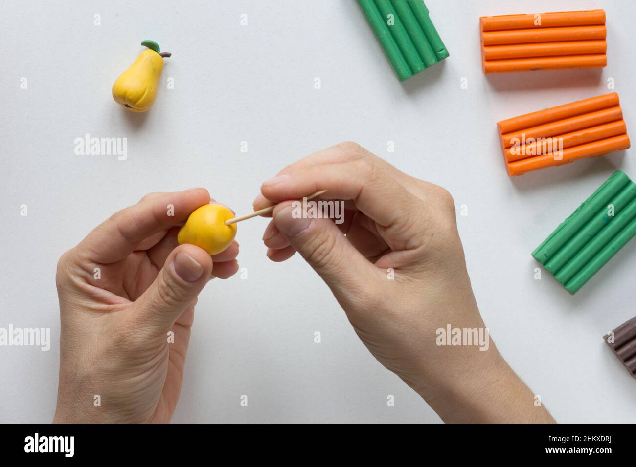 Woman hands making dot on the yellow ball with tooth stick to create ...