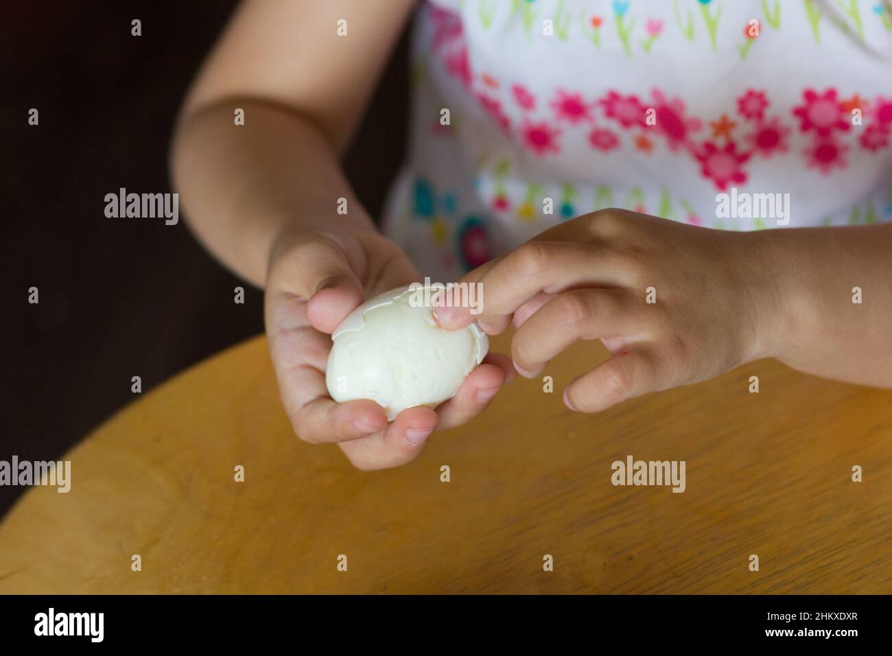 Hand of child peeling cooked egg pulling off shell Stock Photo - Alamy
