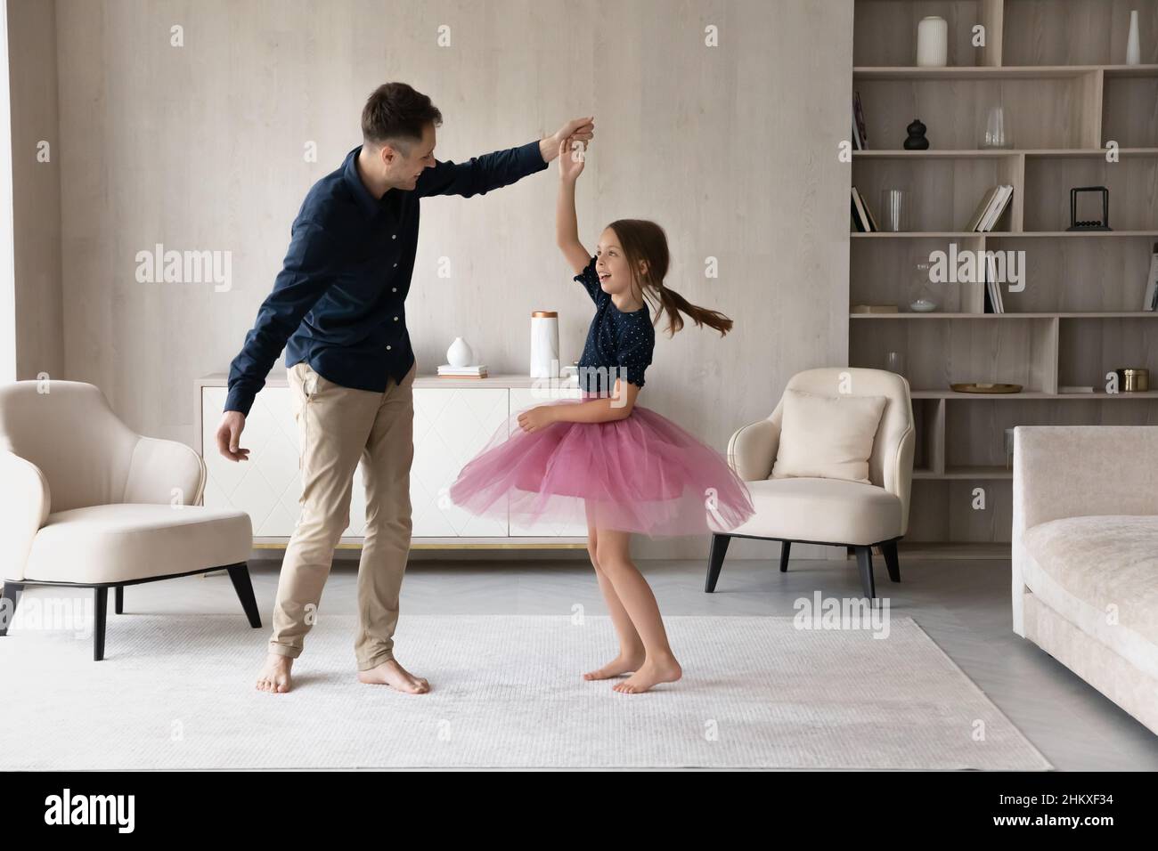 Loving Caucasian father holding daughter hand, dancing at home Stock ...
