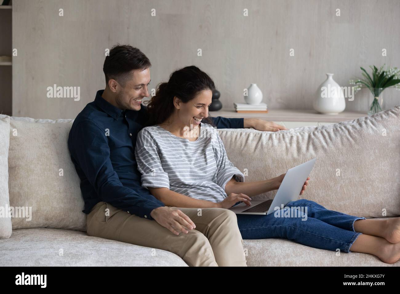 Happy loving couple using laptop, relaxing on couch together Stock ...