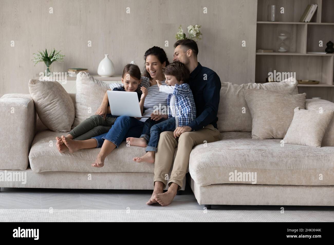 Happy parents with children using laptop, having fun online Stock Photo ...