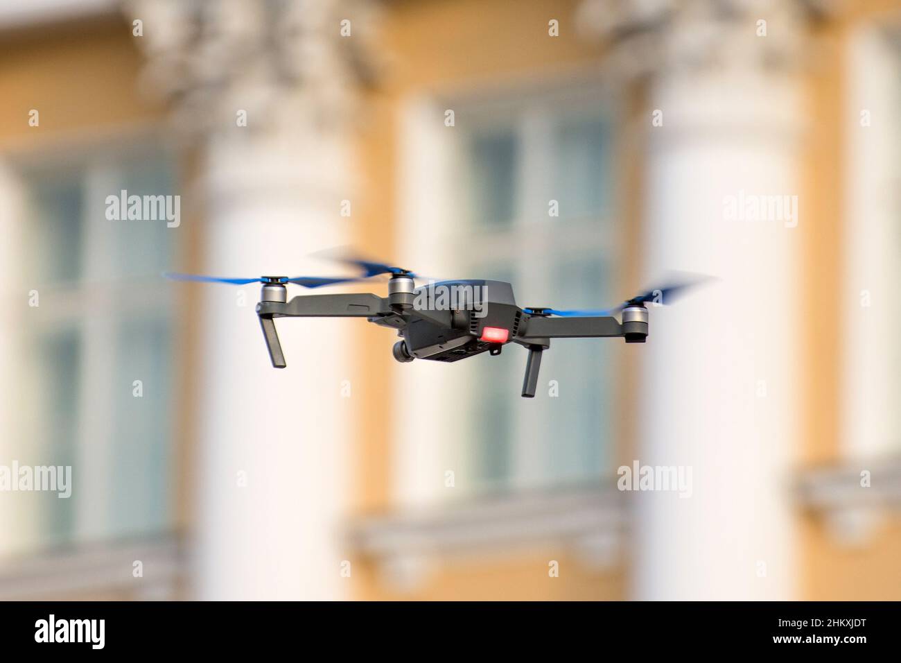 Drone quad copter is flying against the background of windows and ...