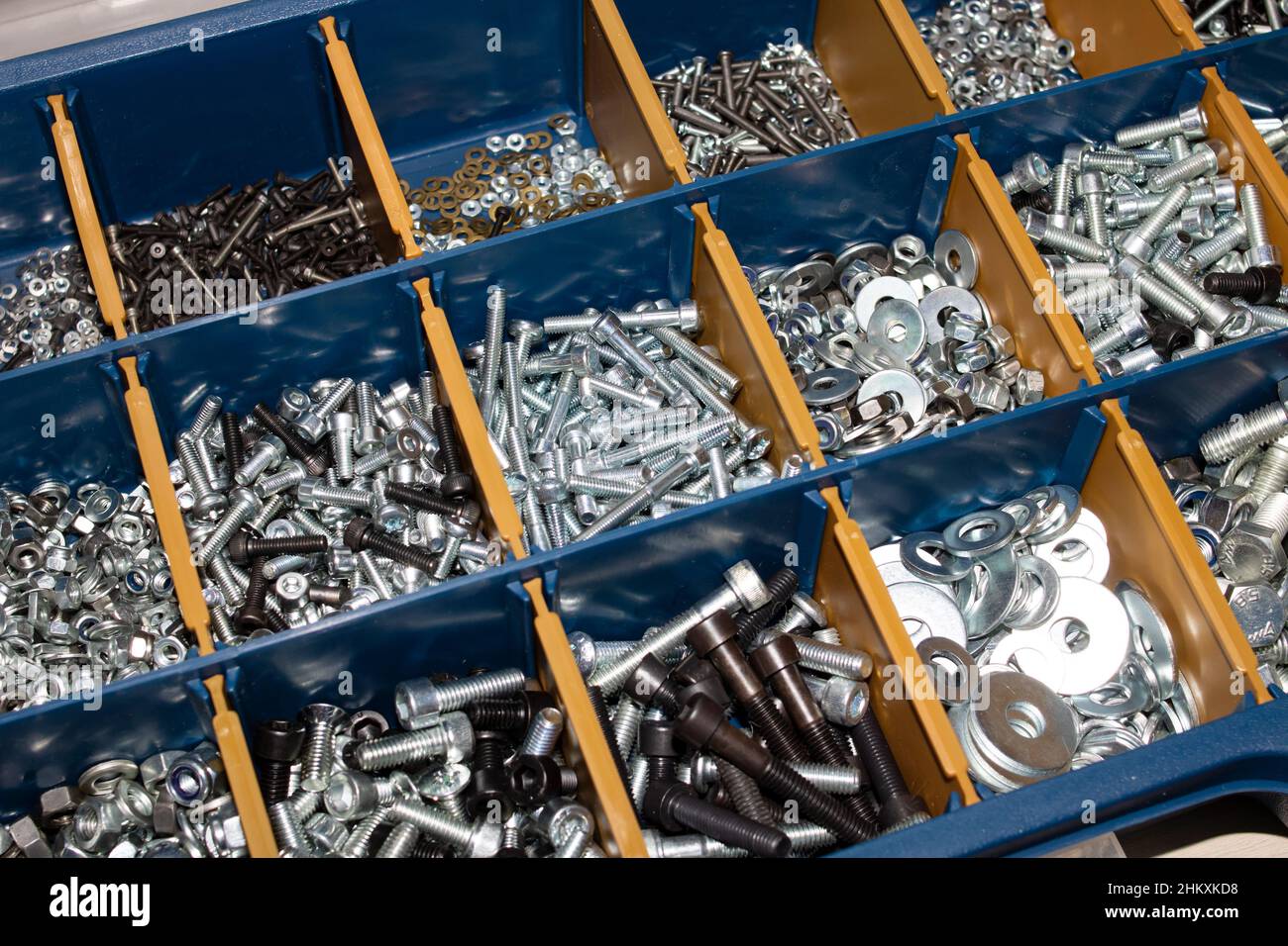 Many bolts in a plastic container close up Stock Photo - Alamy