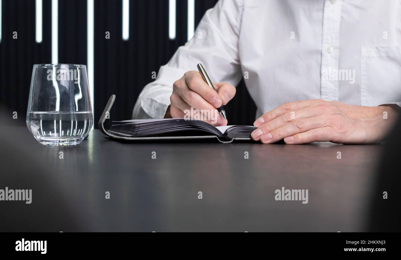 Closeup hands taking notes in planner, planning business appointments ...