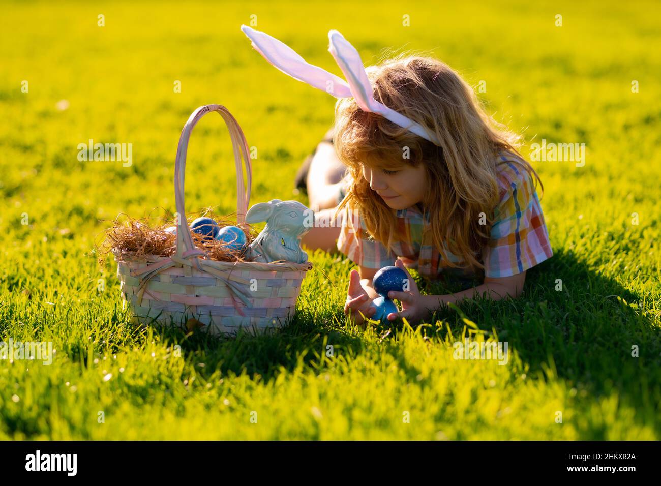 Child boy hunting easter eggs. Cute kid in rabbit costume with bunny ...