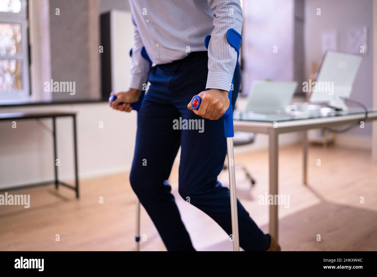 Worker With Crutches At Workplace Or Office. Handicap Rehabilitation ...