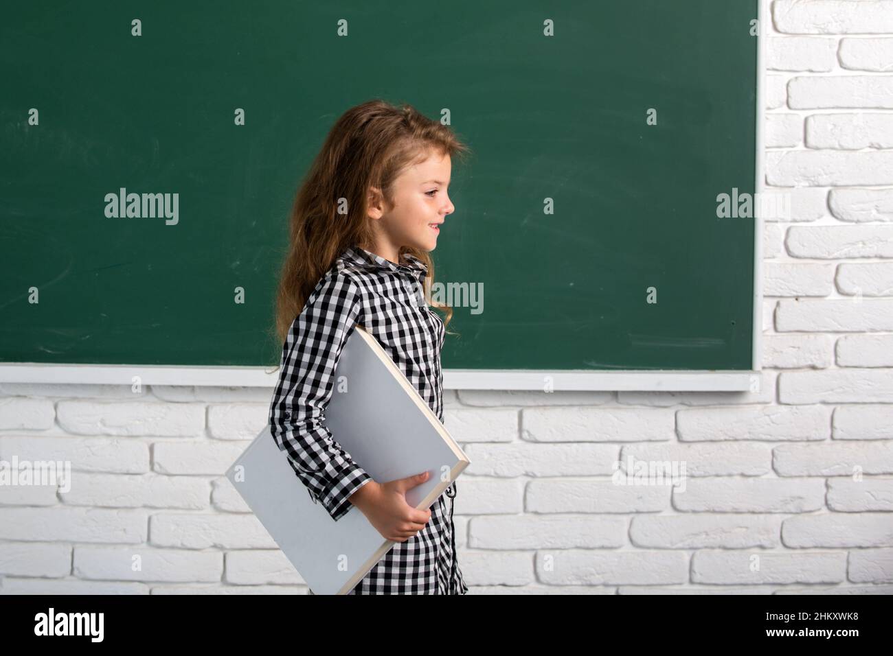 Cute child at school. Kid is learning in class on background of ...