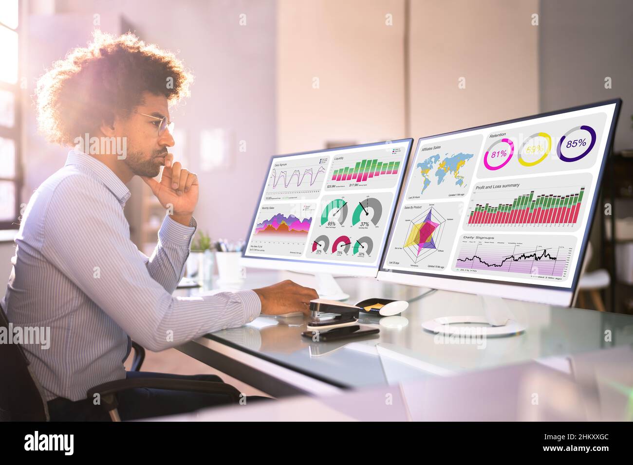 African American Financial Analyst Man Using Multiple Computers Stock