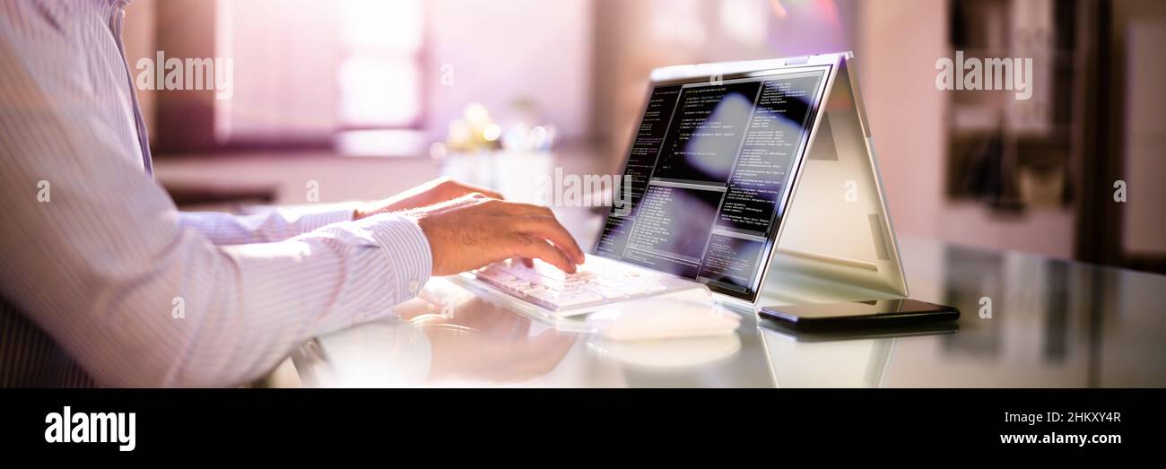 Programmer Or Coder At Office Desk Using Laptop Stock Photo - Alamy