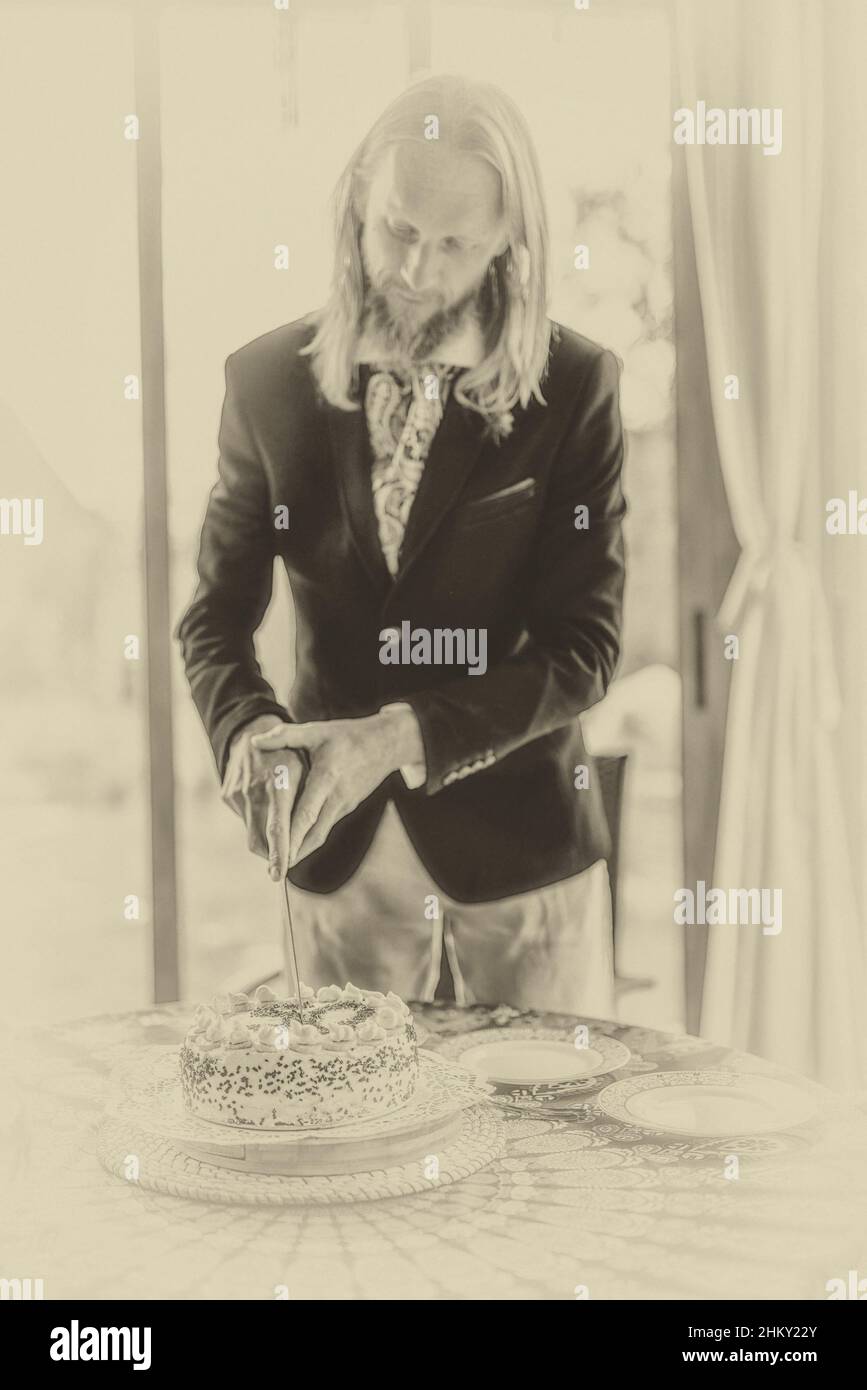 man at a party cutting a cake. Old photo effect Stock Photo - Alamy