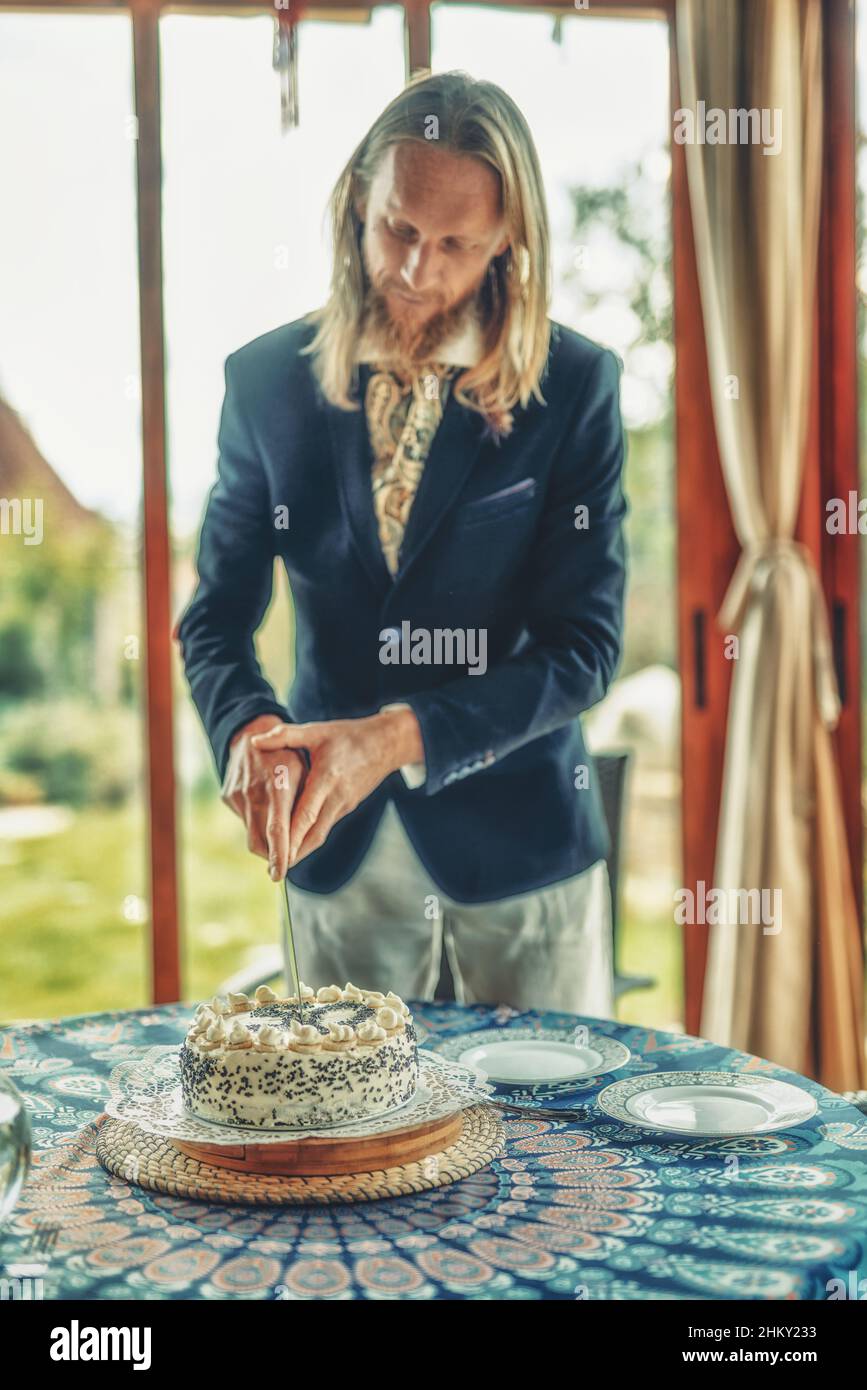 man at a party cutting a cake Stock Photo - Alamy