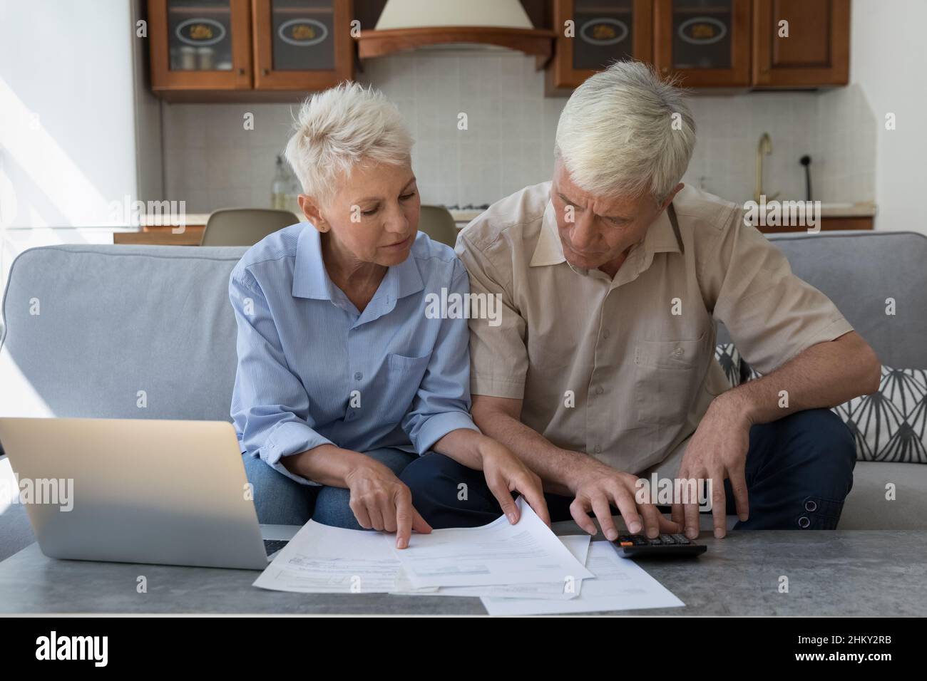 Focused older 60s husband and wife paying paper bills Stock Photo - Alamy