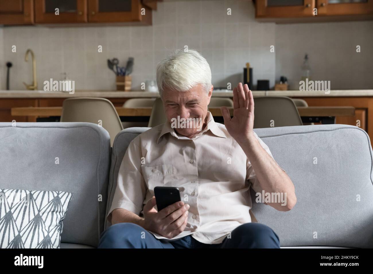 Joyful happy older 70s cellphone user man waving hand hello Stock Photo ...