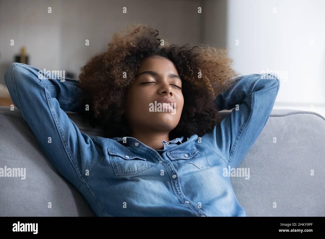 Calm sleepy teen African girl relaxing on comfortable sofa Stock Photo ...
