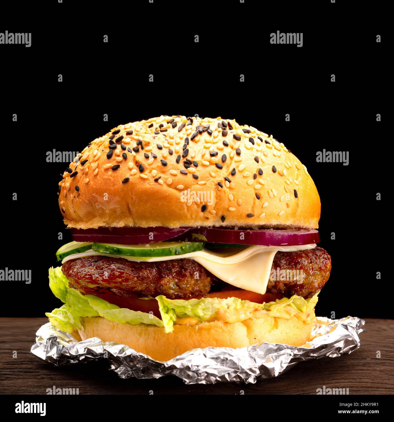 Big single cheeseburger isolated on black background Stock Photo - Alamy