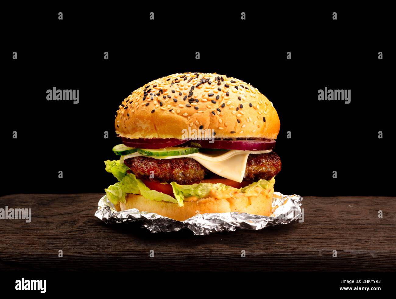 Big single cheeseburger isolated on black background Stock Photo - Alamy