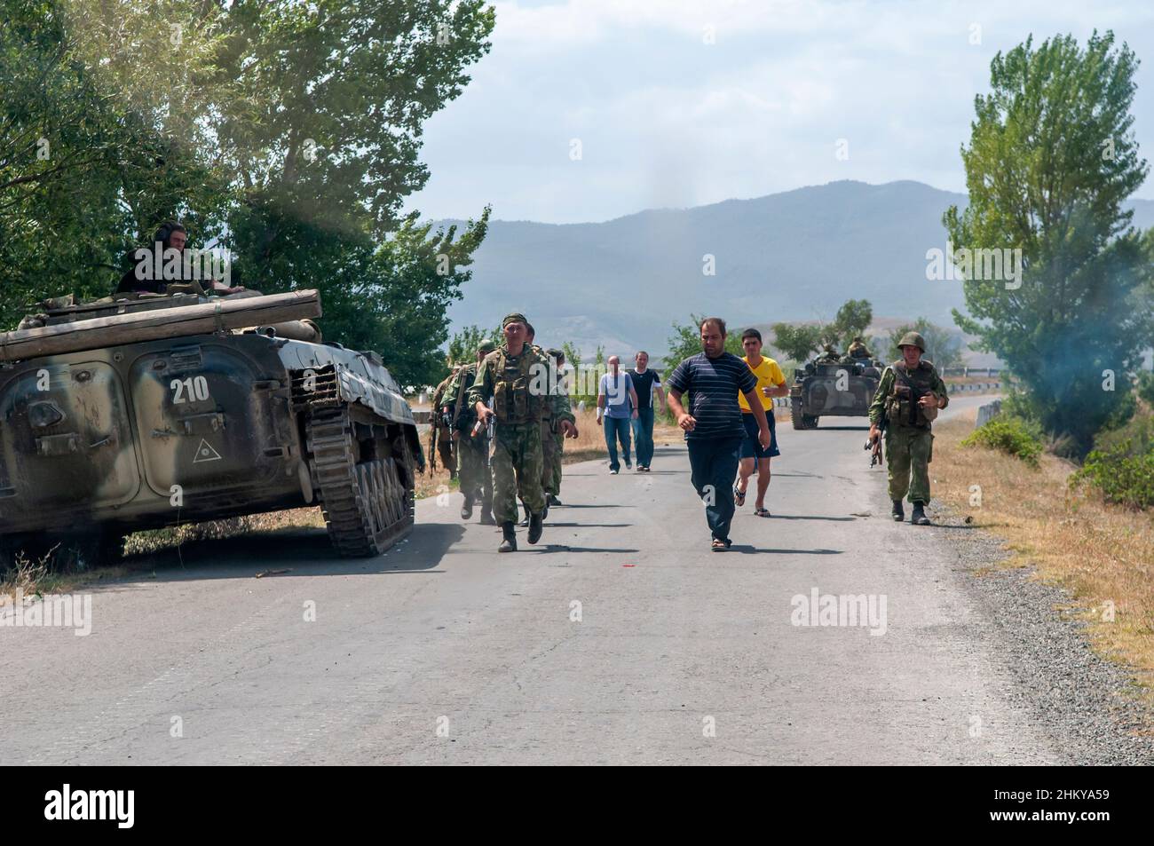 Georgian civilians walk past Russian troops as they flee the city of ...