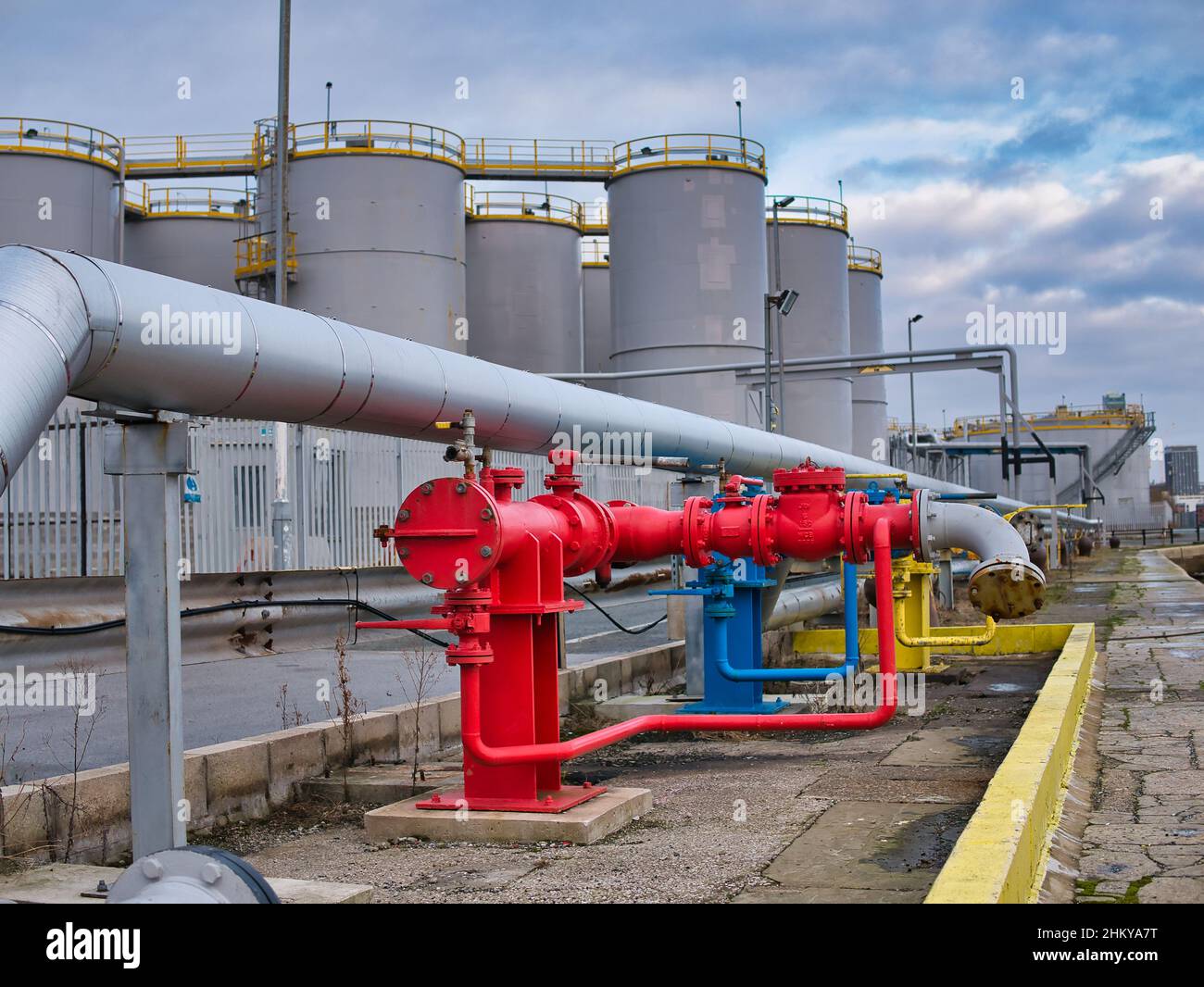 Brightly coloured industrial pipelines, control valves and a low yellow ...
