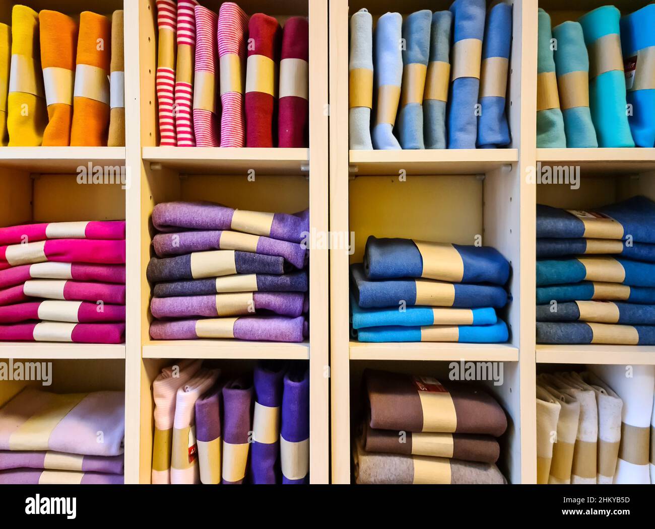 Fabrics of different colors on a shelf with many compartments in a ...