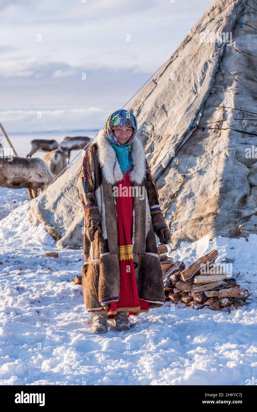A Nenet young woman in front a typical chum (tent). Yamalo-Nenets ...