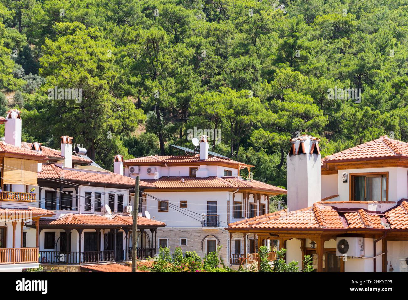 A view of vintage houses with tile roof in forest. Traditional Akyaka ...