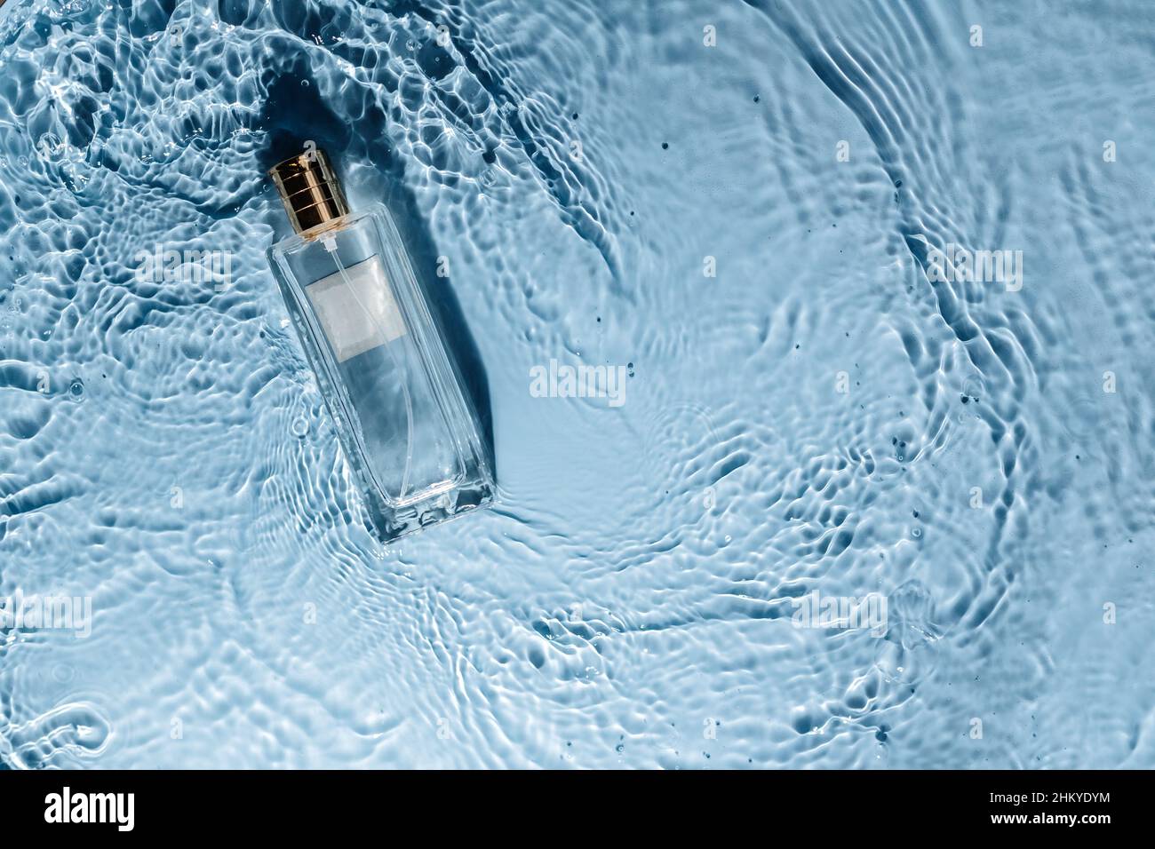 Perfume bottle on blue water wavy background. Fresh sea fragrance ...