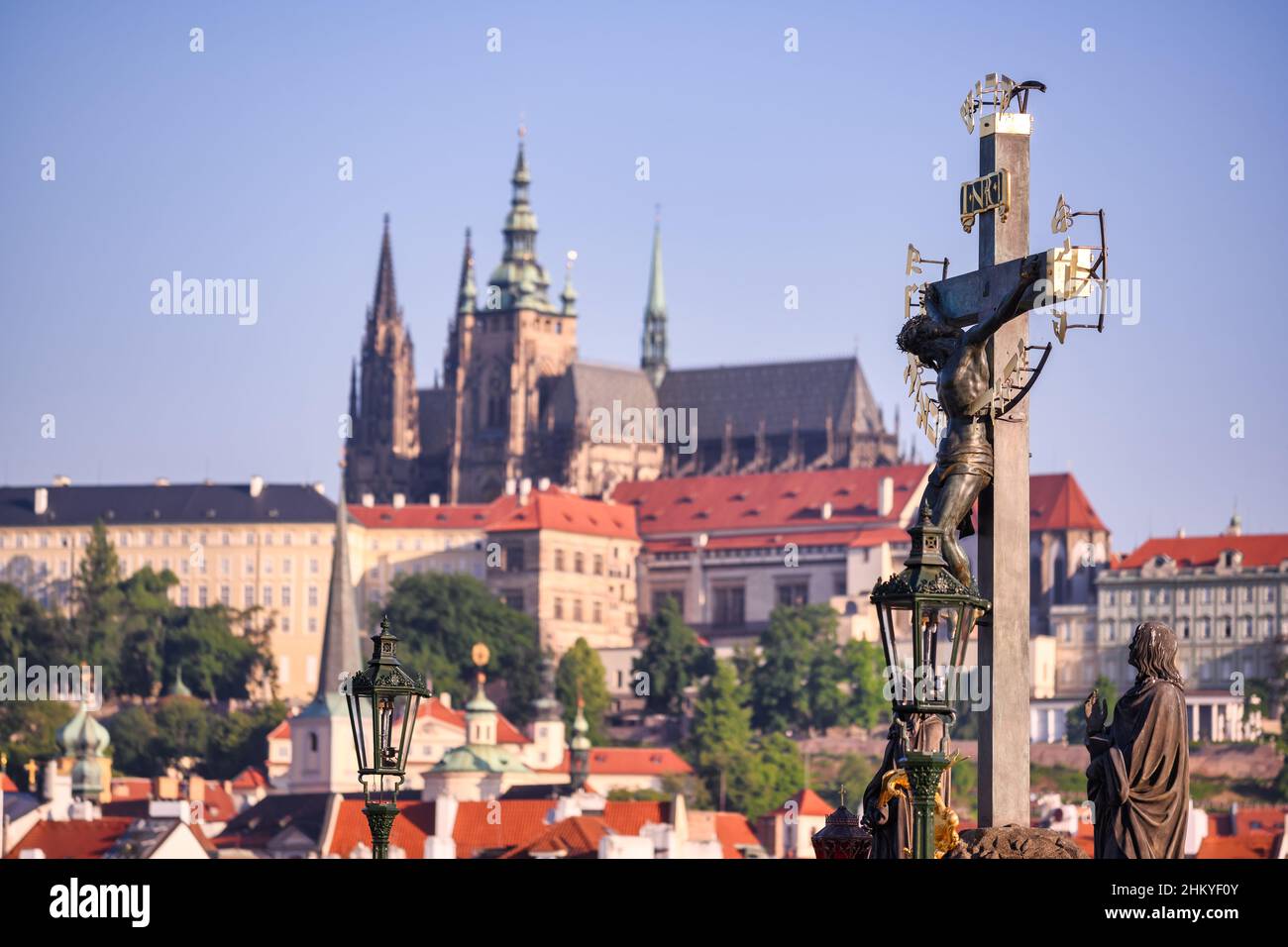 Cross with Jesus on Charles Bridge in Prague. In the background Prague ...