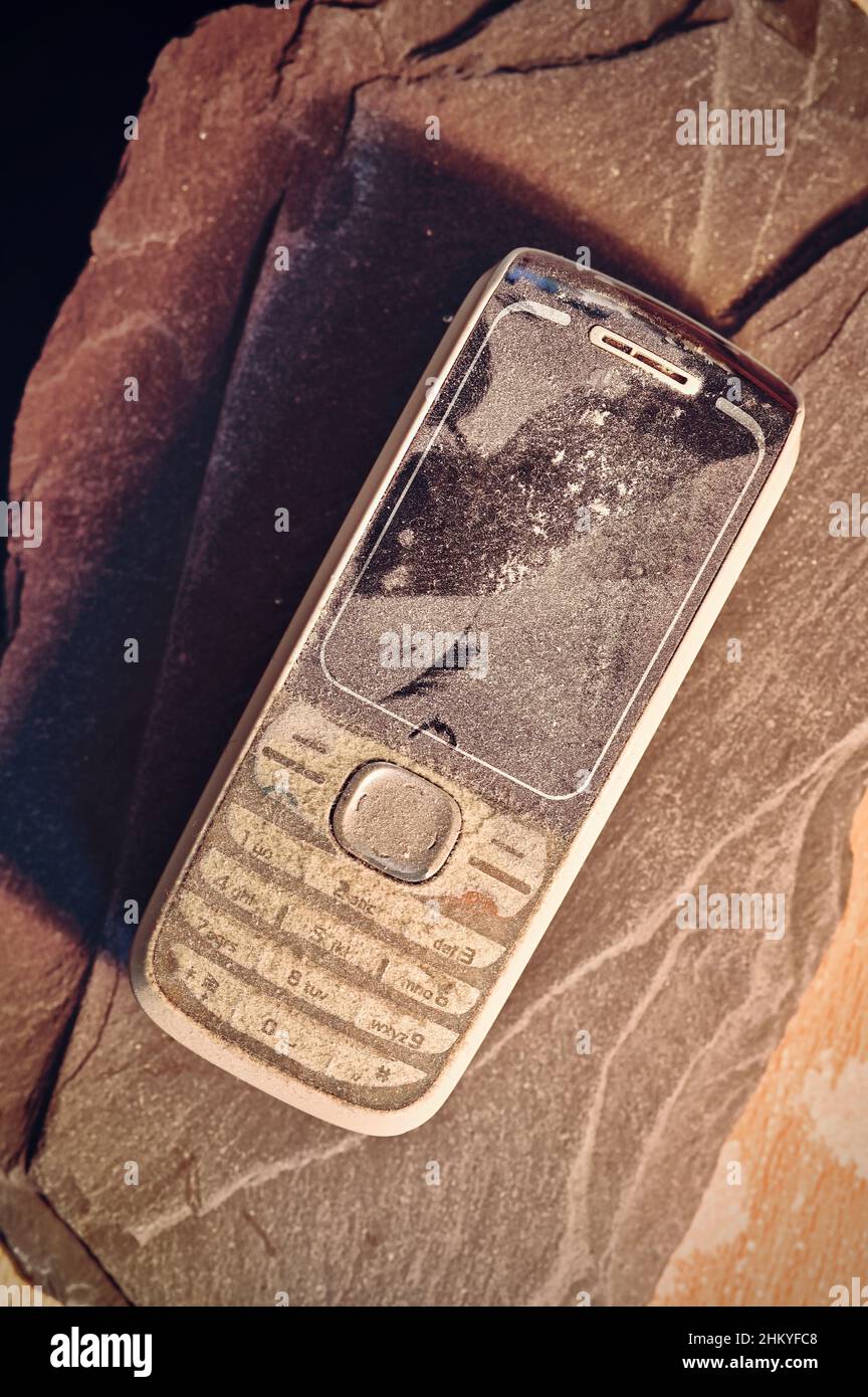 Dirty old mobile phone sat on a slate background Stock Photo - Alamy
