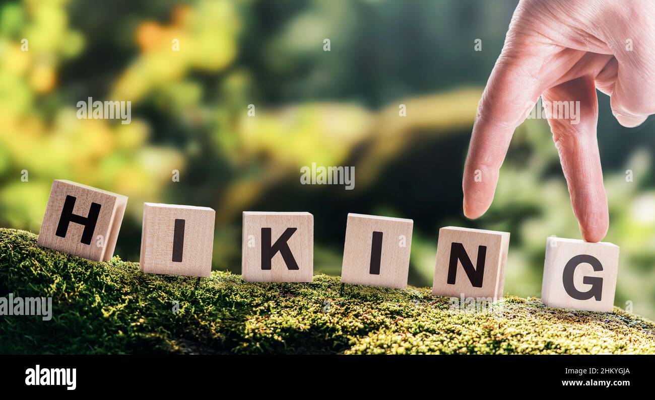 hiking word text on cubes on a forest background. Man walking, mountain ...
