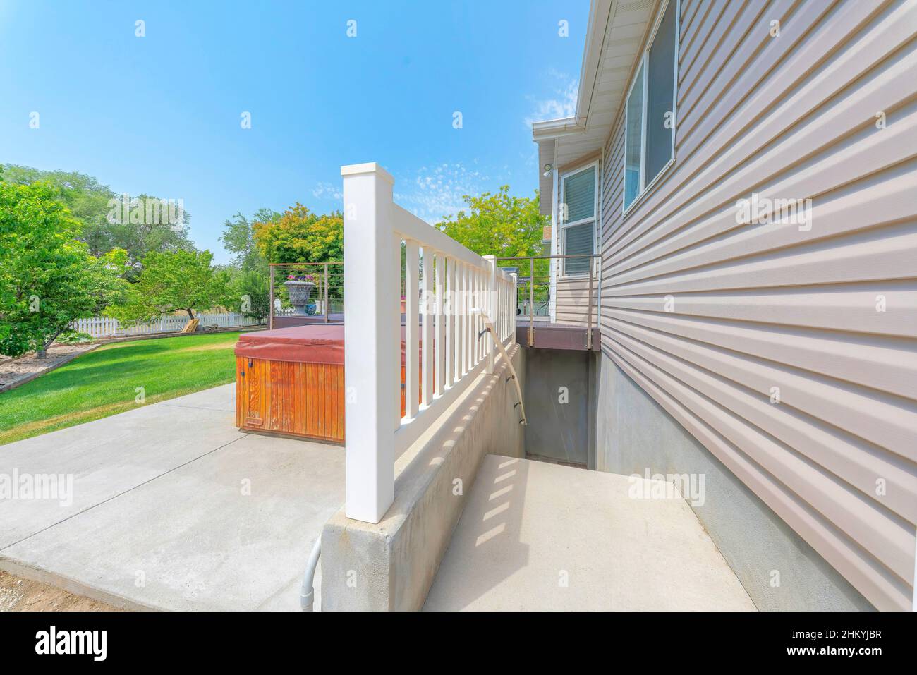 Narrow basement entrance with railings beside the wood viinyl sidings ...