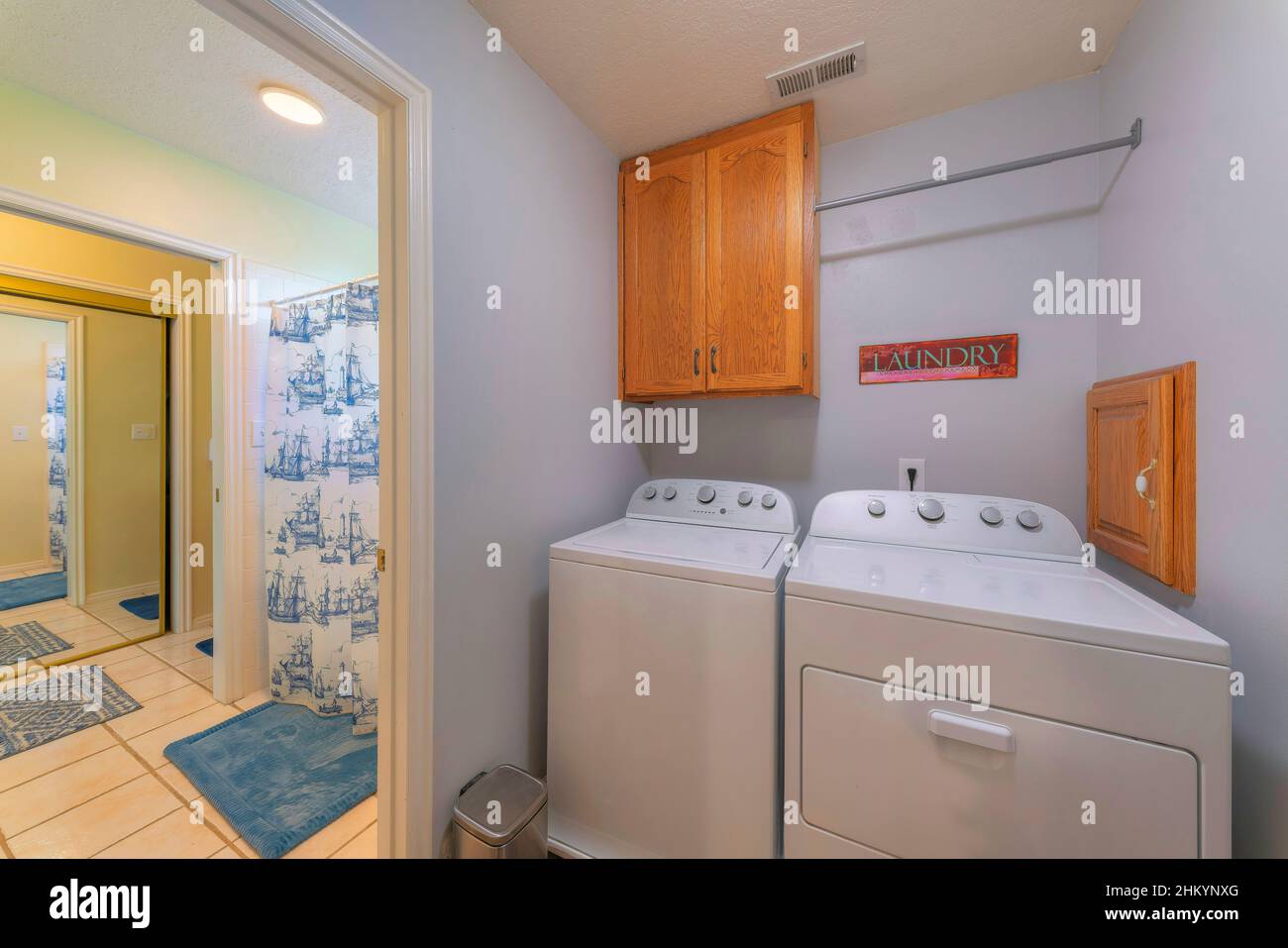 Laundry room beside the bathroom with large mirror door Stock Photo - Alamy