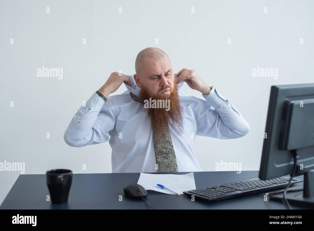 Problems for the office worker. A bald man in a white shirt sits at a ...