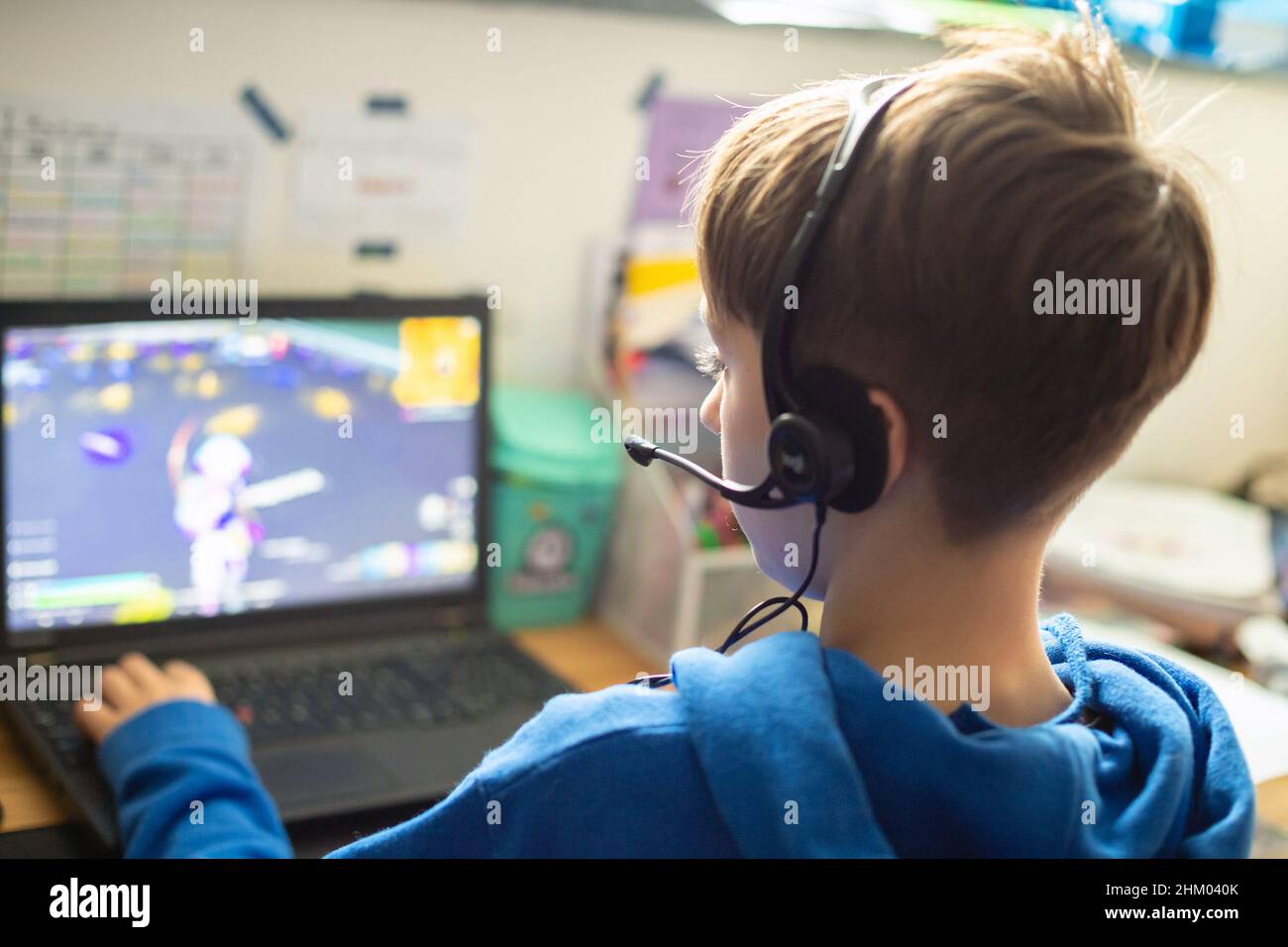 Child gaming on laptop playing addictive online video game at home in ...