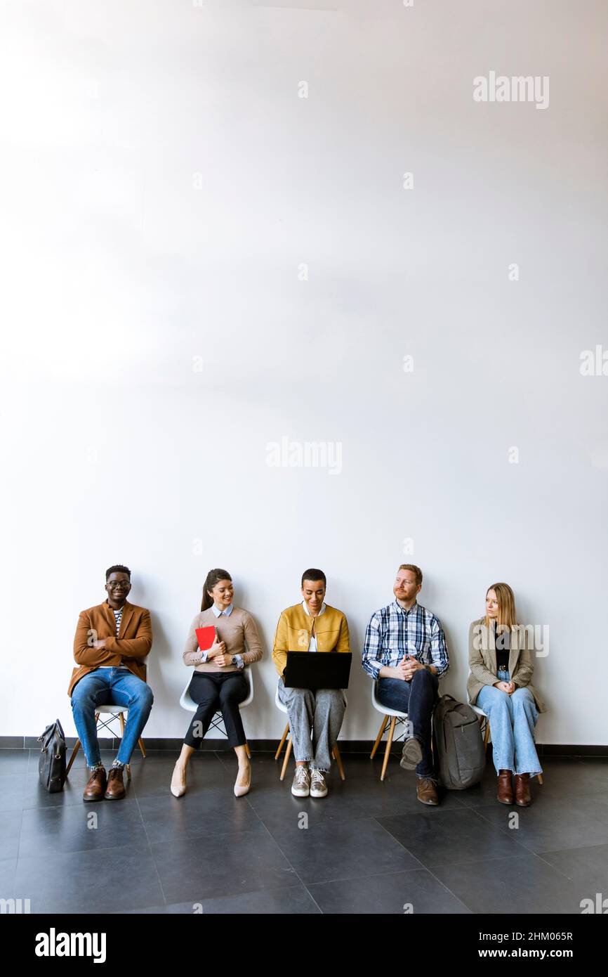 Group of bored young people waiting for the job interview Stock Photo ...