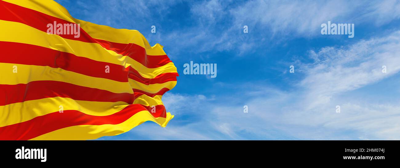 flags of Catalonia waving in the wind on flagpoles against sky with ...