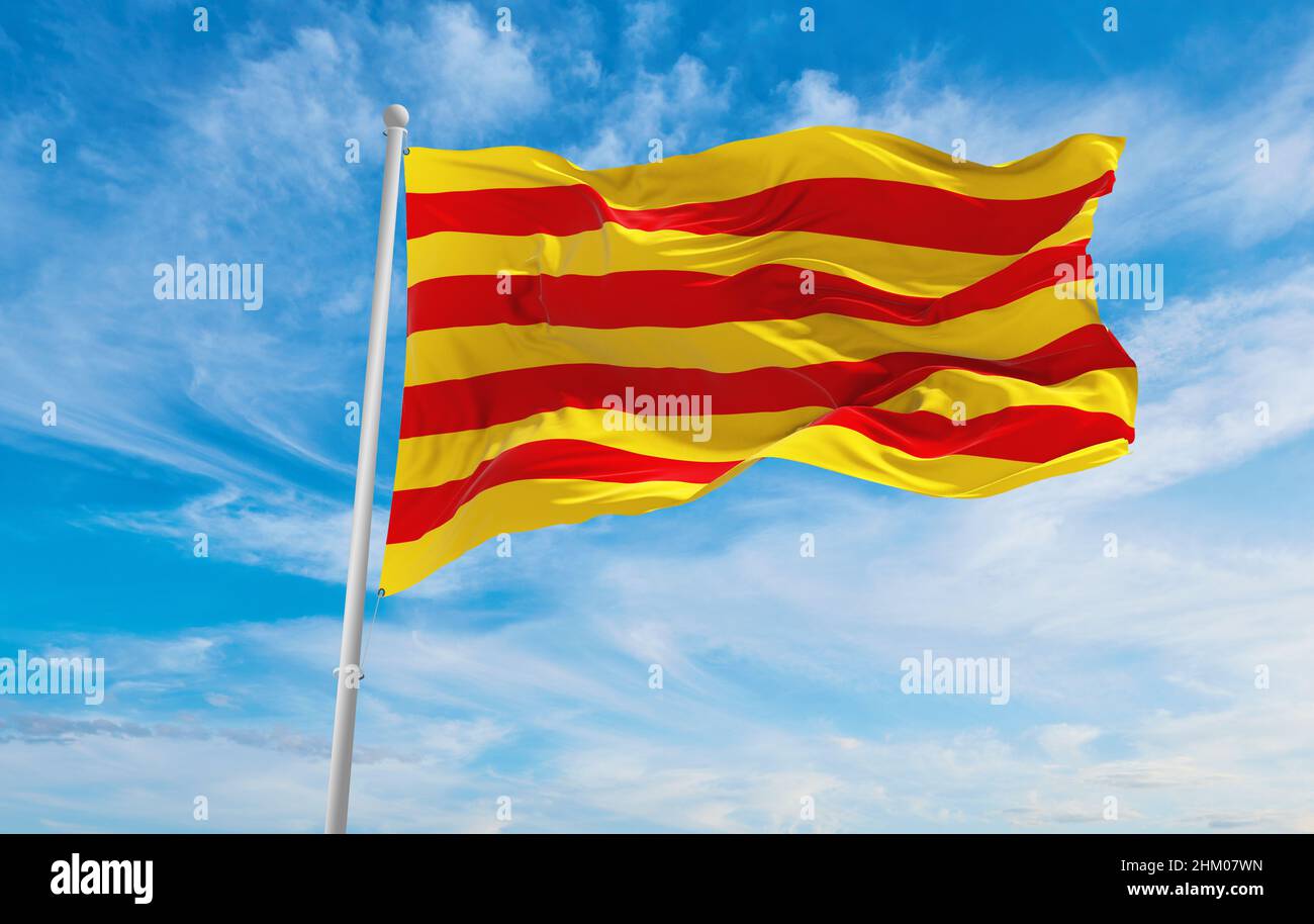 flags of Catalonia waving in the wind on flagpoles against sky with ...
