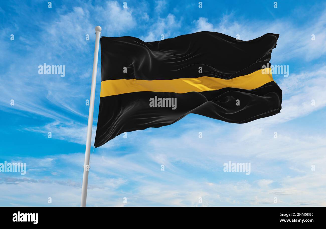 Thin Gold Line flag waving at cloudy sky background on sunset ...