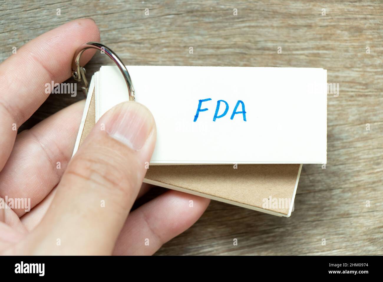 Man hold the flash card with handwriting word FDA (abbreviation of food ...