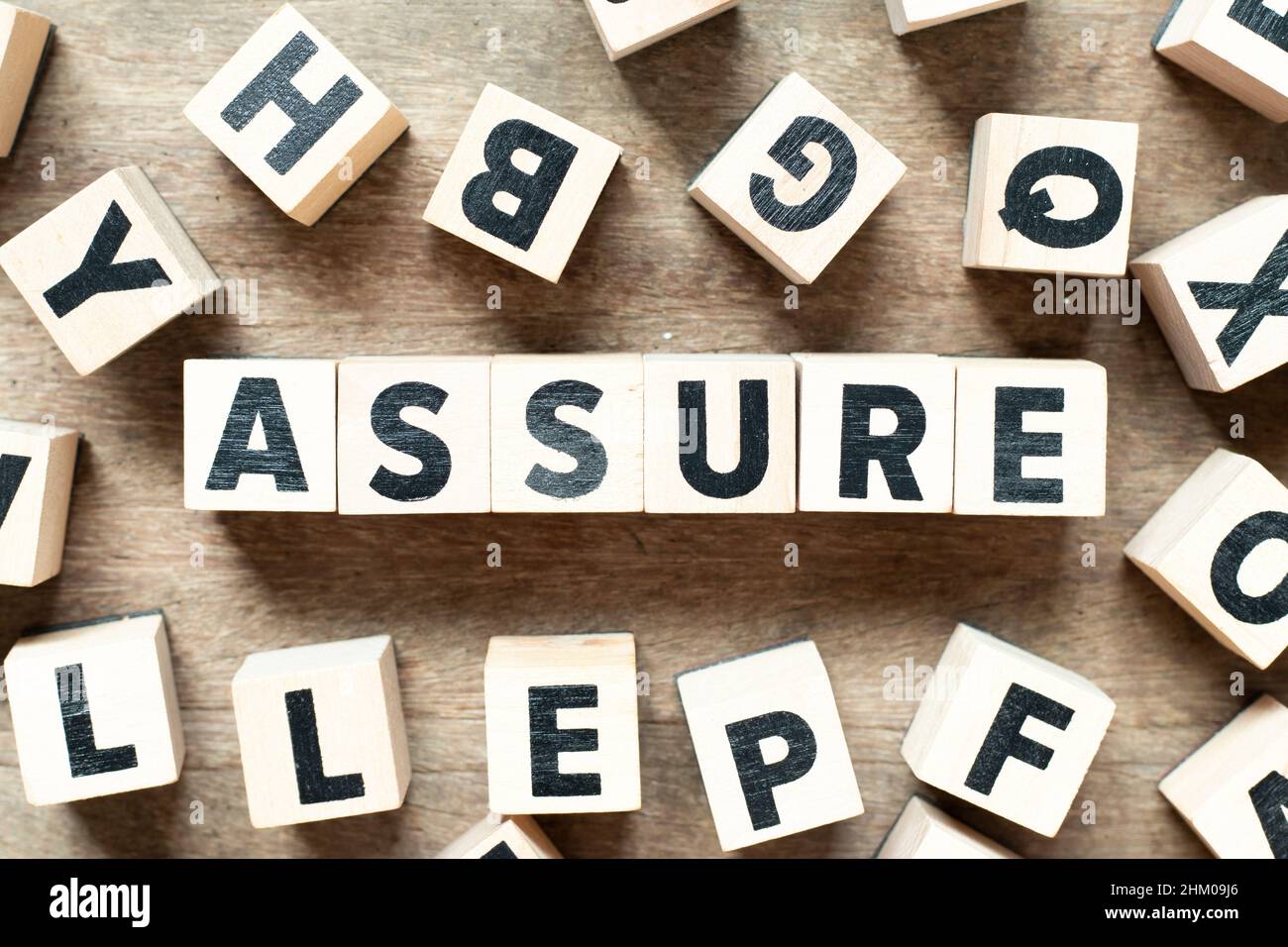 Alphabet letter block in word assure with another block on wood ...