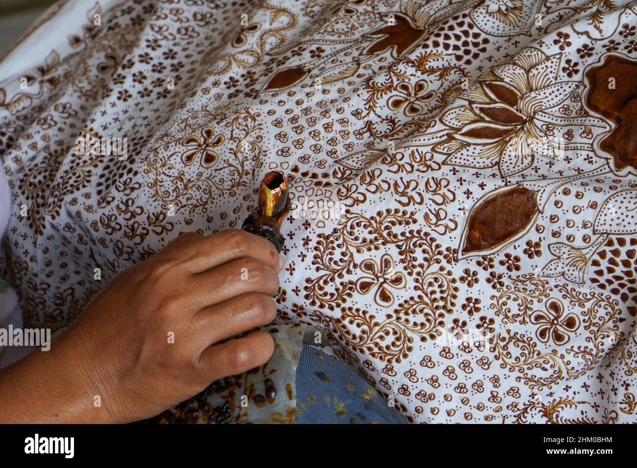 The technique of making batik by writing using a canting tool. Canting ...