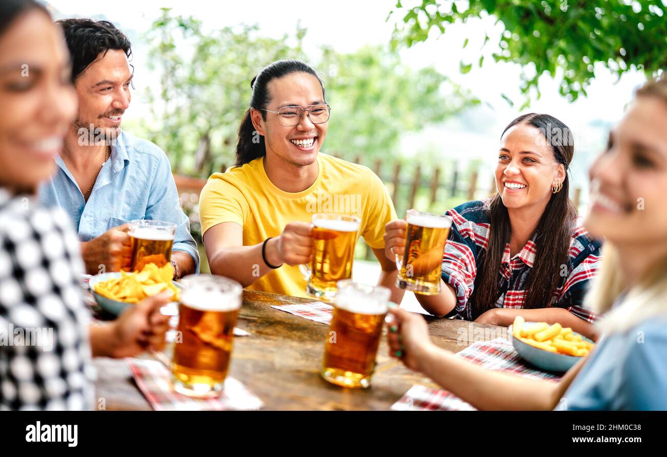 Young happy friends drinking and toasting beer at brewery bar ...