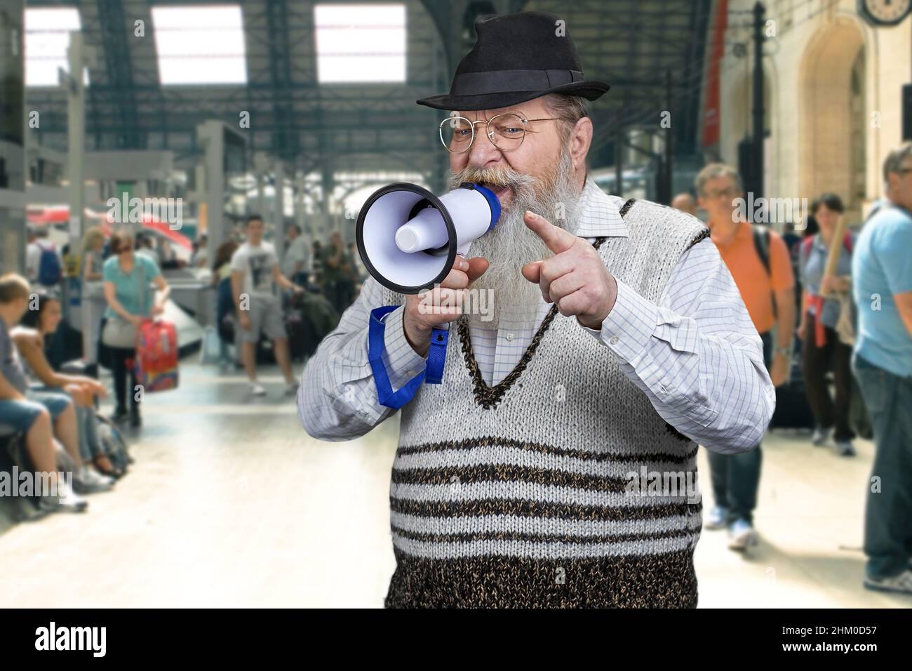 Confident senior man talking into megaphone. Blur background of train ...