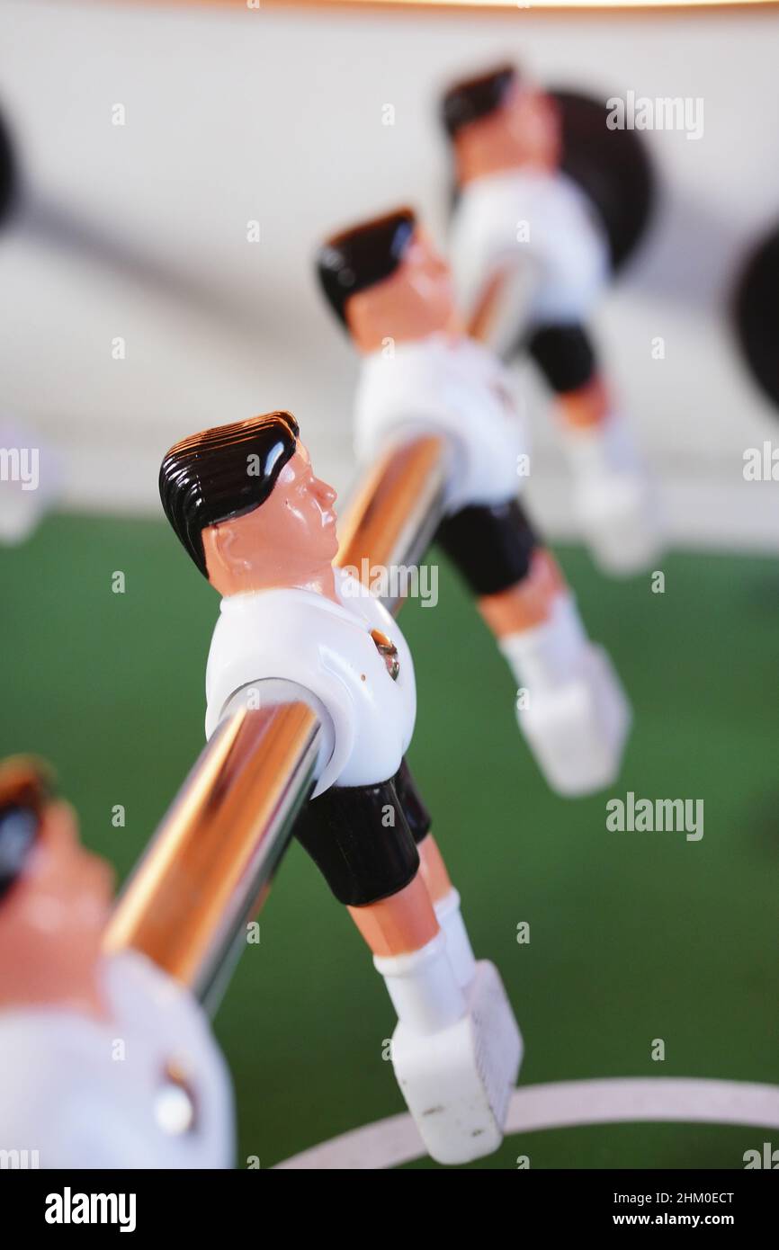 A vertical shot of a plastic figure of a table soccer in white and ...