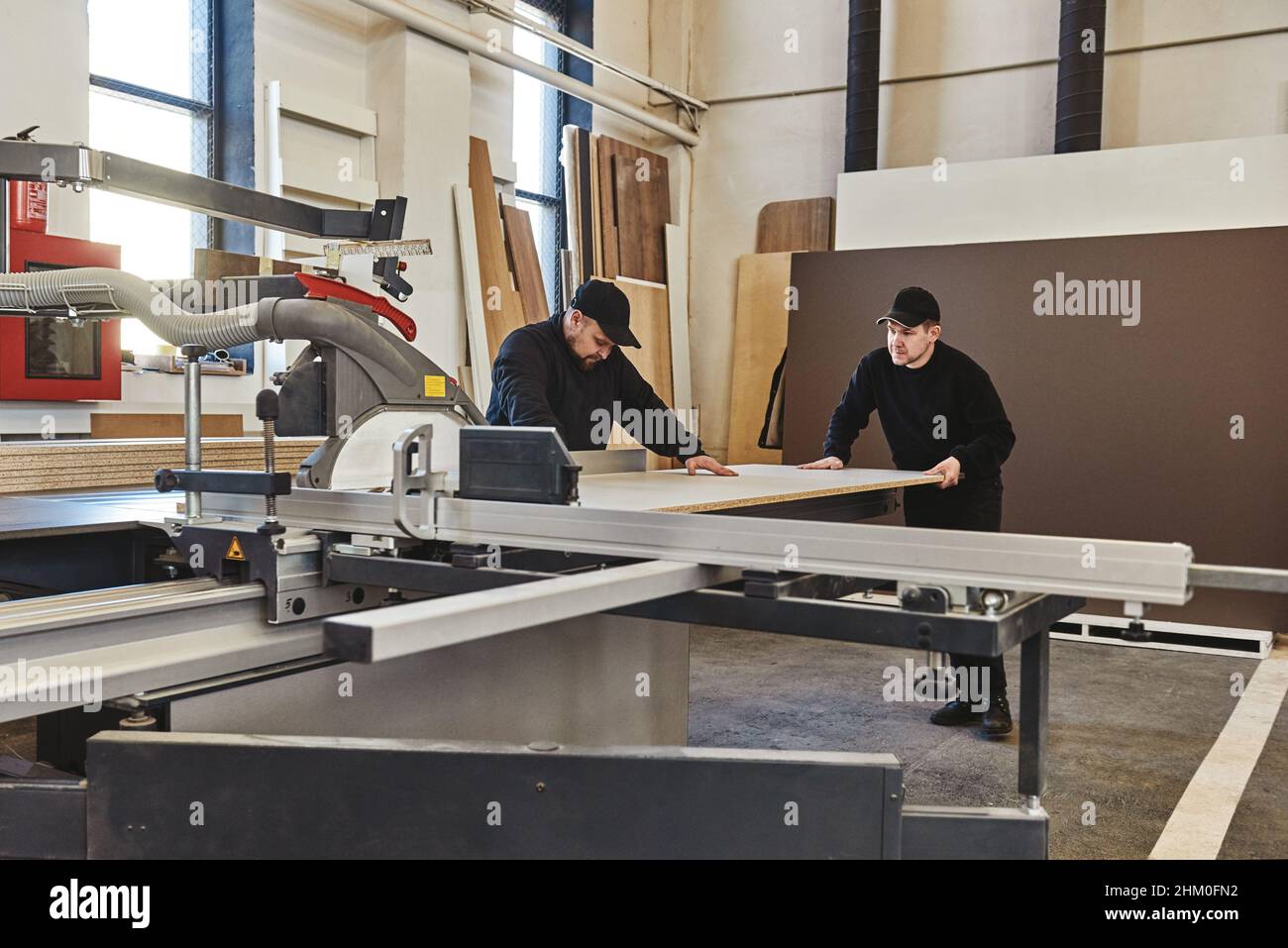 Men at work sawing wood. Circular saw. A machine which saws wood ...