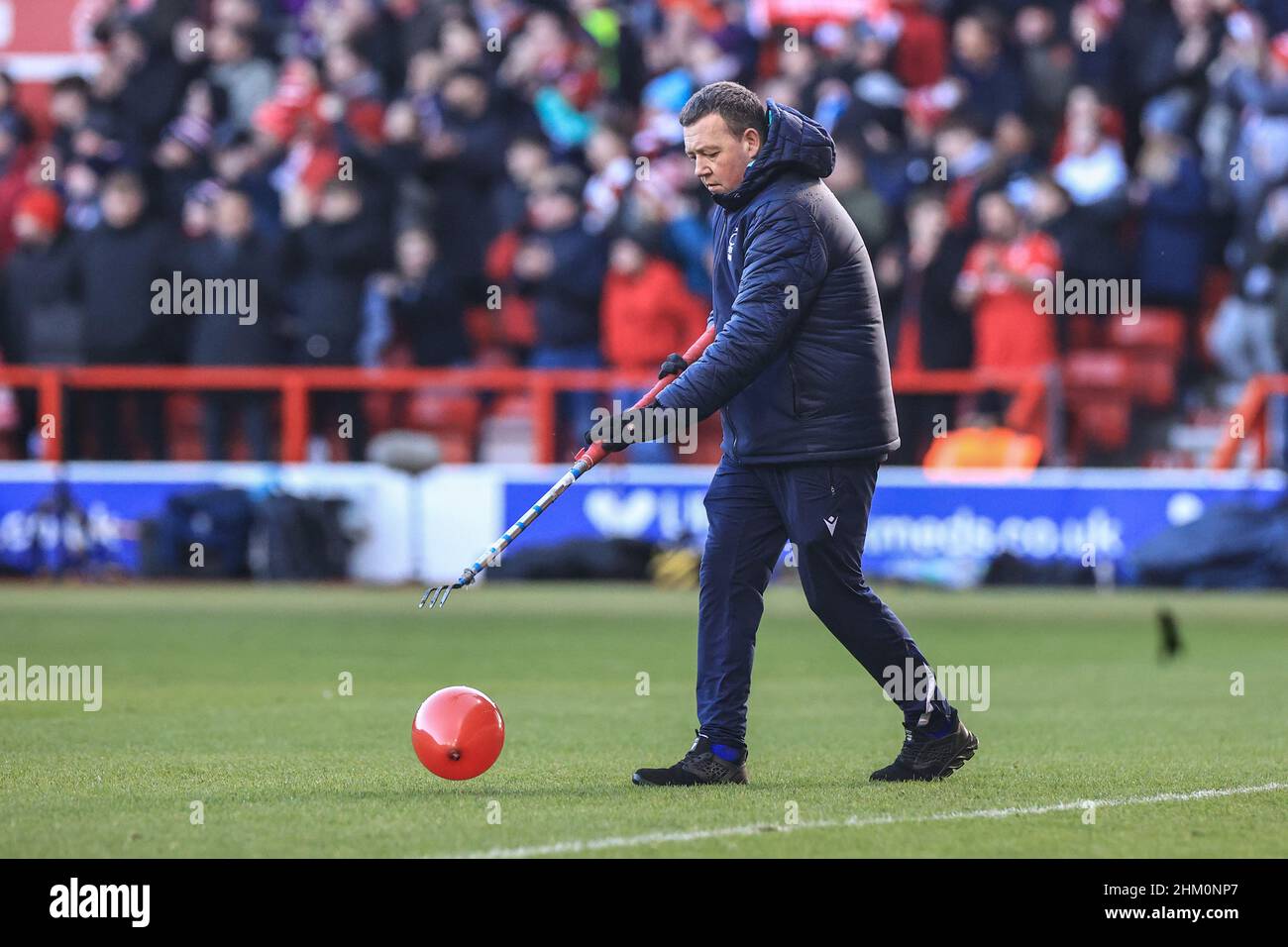 A ground staff pops a red balloon Stock Photo - Alamy